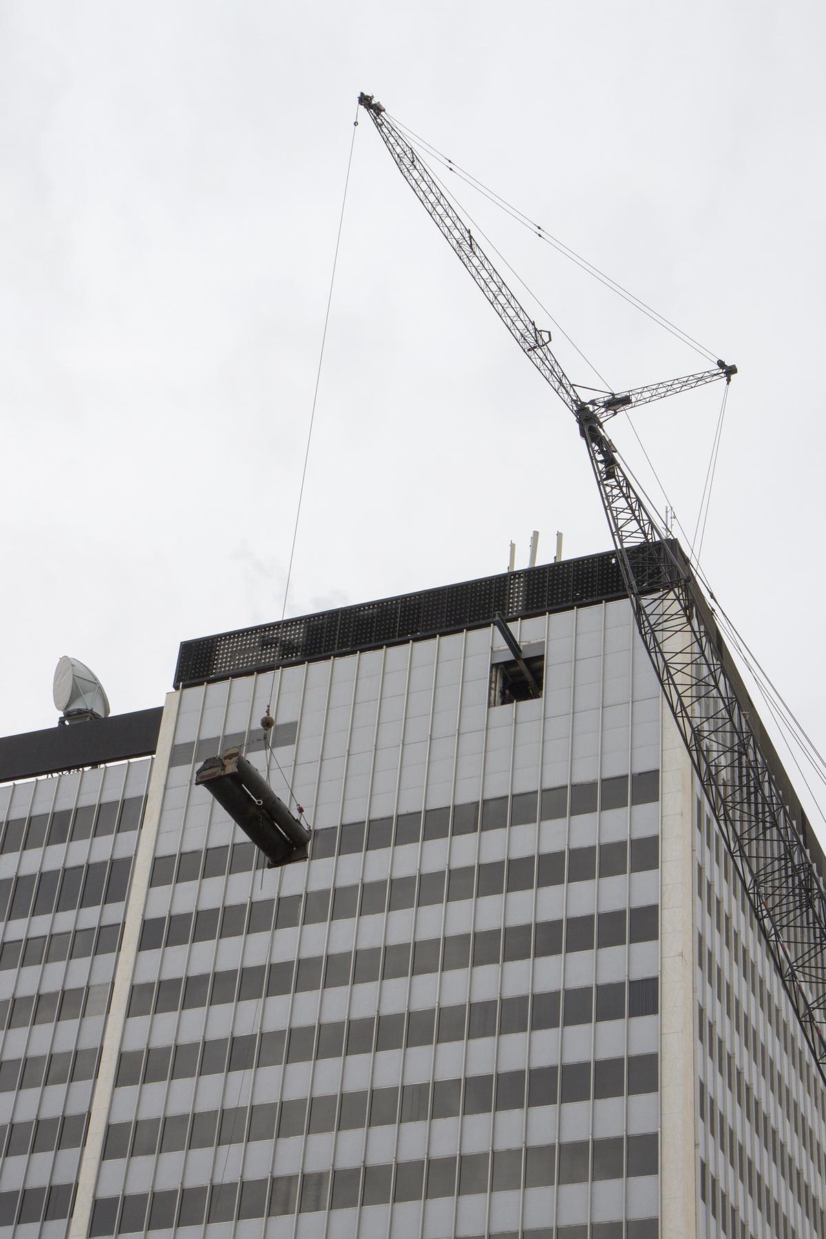 Finally, wind calms enough to hoist chiller to top of office tower ...