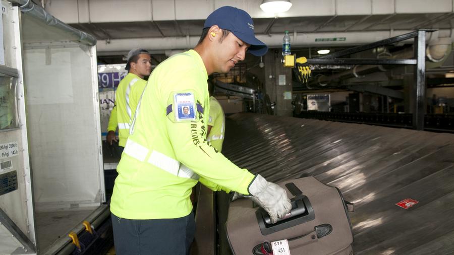 Hawaiian Airlines ramp agent sorting luggage