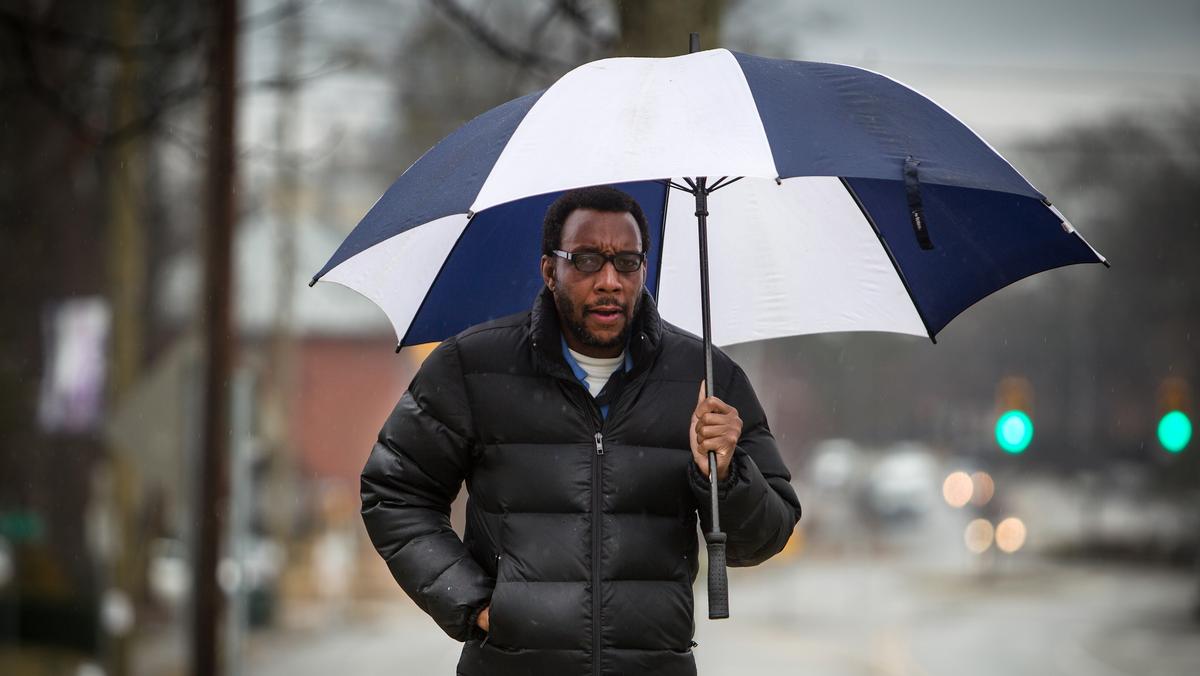 Raleigh resident Dallas Hinton on his way to work on a rainy Feb. 23 in ...