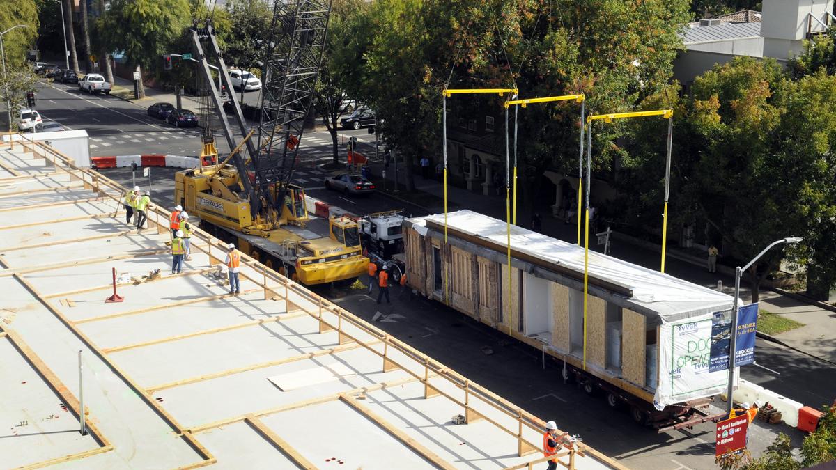 Builders stack prefabricated apartments into place for Eviva project in ...